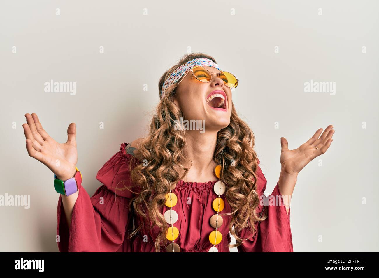 Young blonde girl wearing bohemian and hippie style celebrating mad and ...