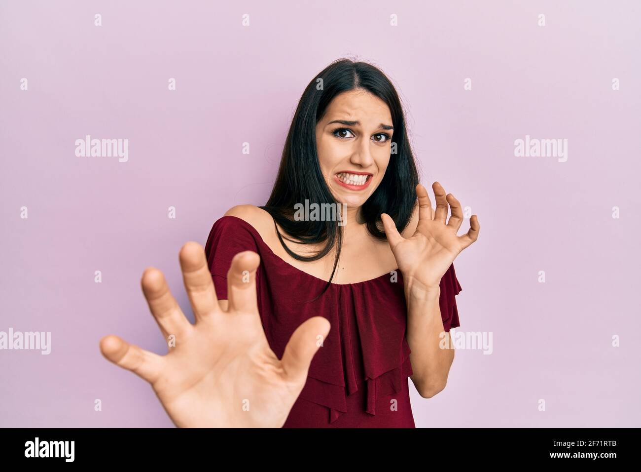 Young hispanic woman wearing casual clothes afraid and terrified with ...