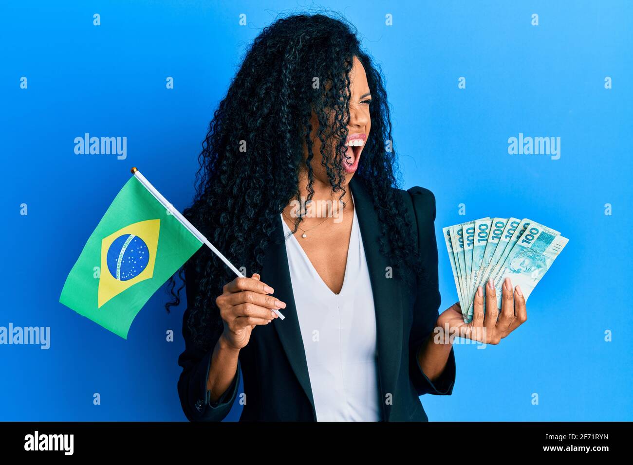 Middle age african american woman holding brazil flag and real ...