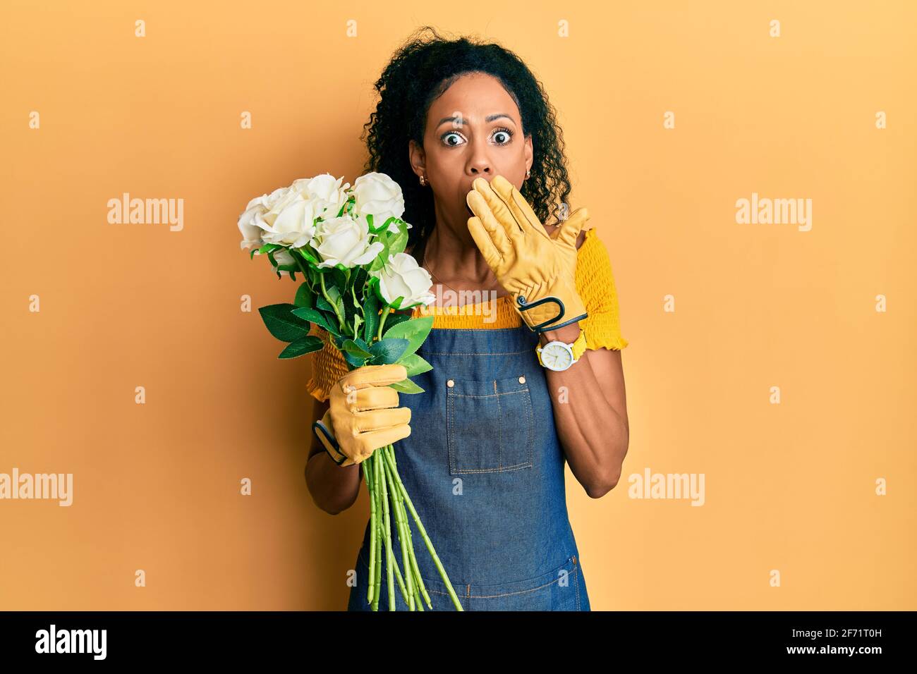Middle age african american woman holding bouquet of white roses ...