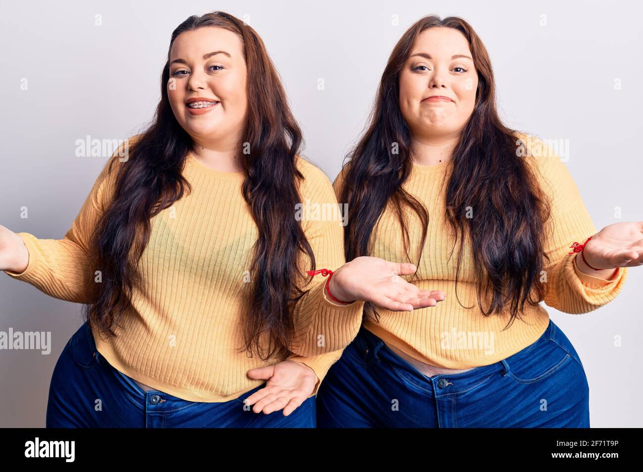 Young plus size twins wearing casual clothes smiling showing both hands ...