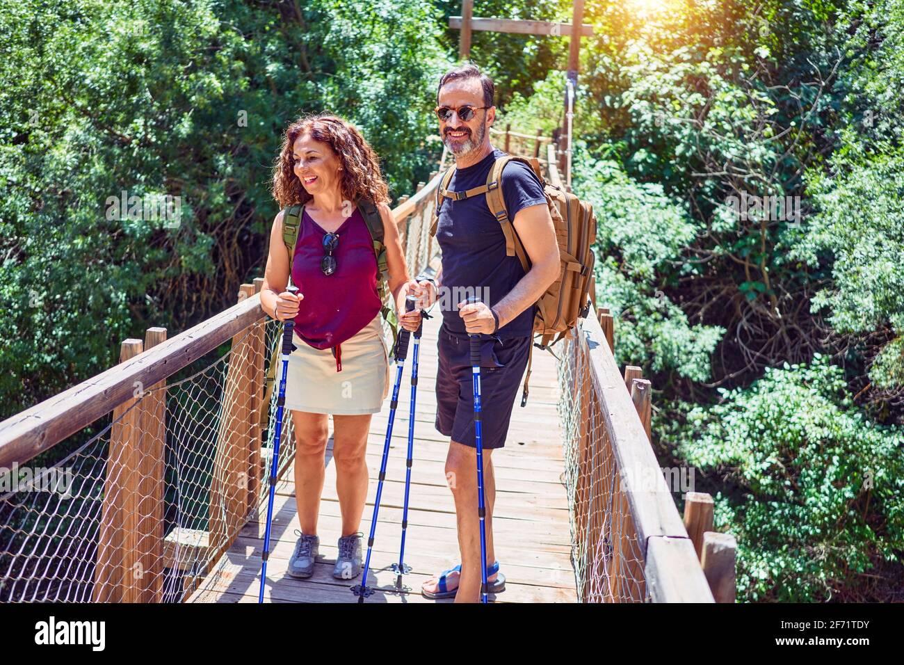 Beautiful couple of hiker wearing explorer clothes and backpack smiling ...