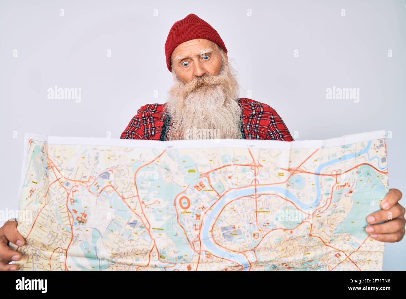 Old senior man with grey hair and long beard holding city map in shock ...