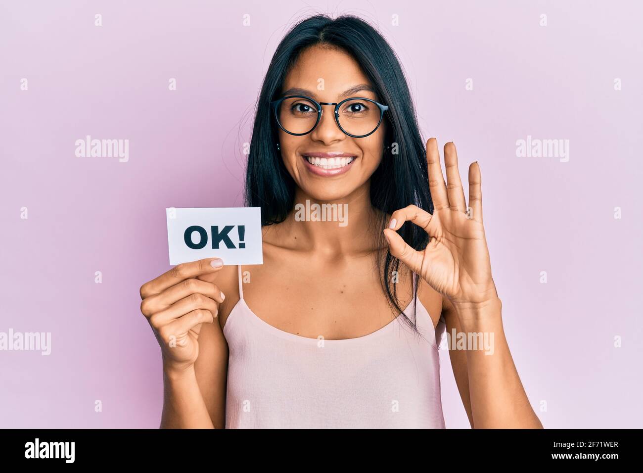 Young african american woman holding ok message paper doing ok sign ...