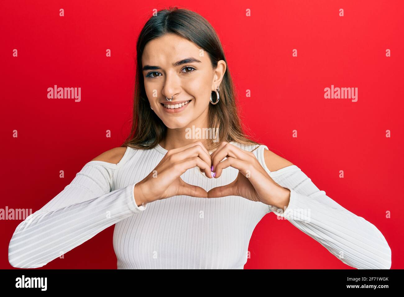 Young Hispanic Woman Wearing Casual Clothes Smiling In Love Doing Heart