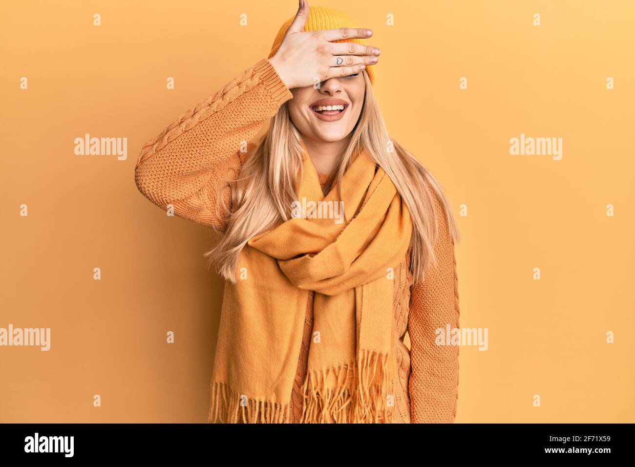 Young caucasian woman wearing wool winter sweater and cap smiling and ...