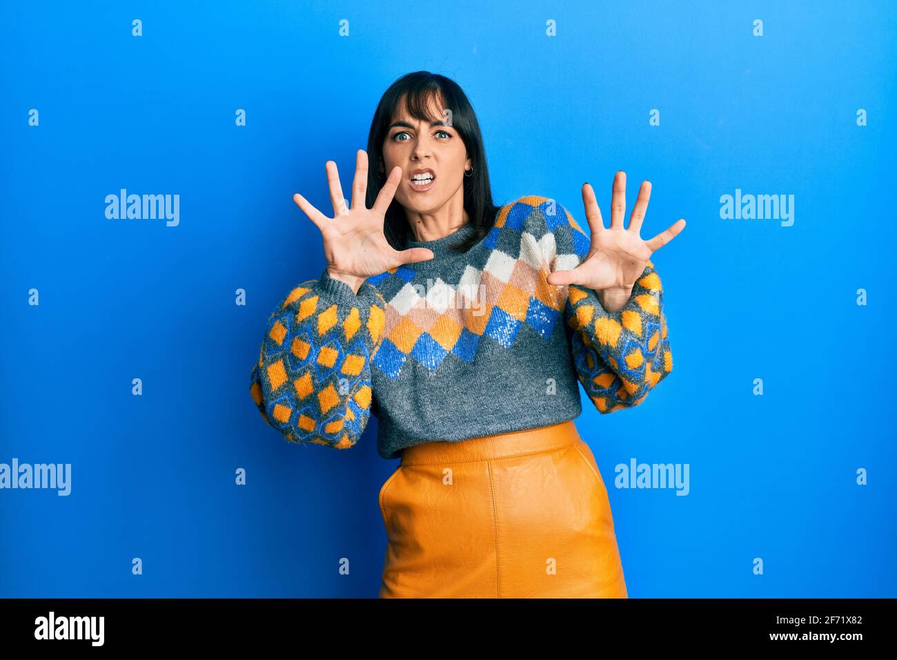 Young hispanic woman wearing casual winter sweater afraid and terrified ...