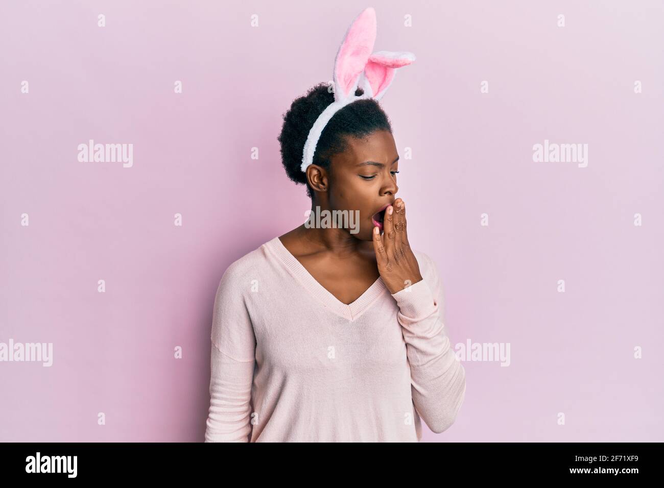 Young african american girl wearing cute easter bunny ears bored ...