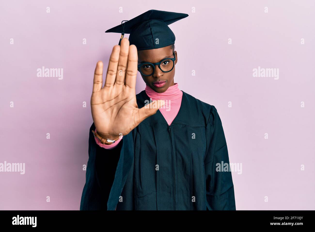Young african american girl wearing graduation cap and ceremony robe ...