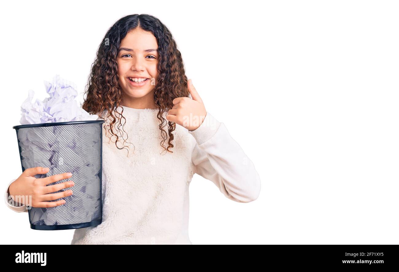 Beautiful kid girl with curly hair holding paper bin full of crumpled ...