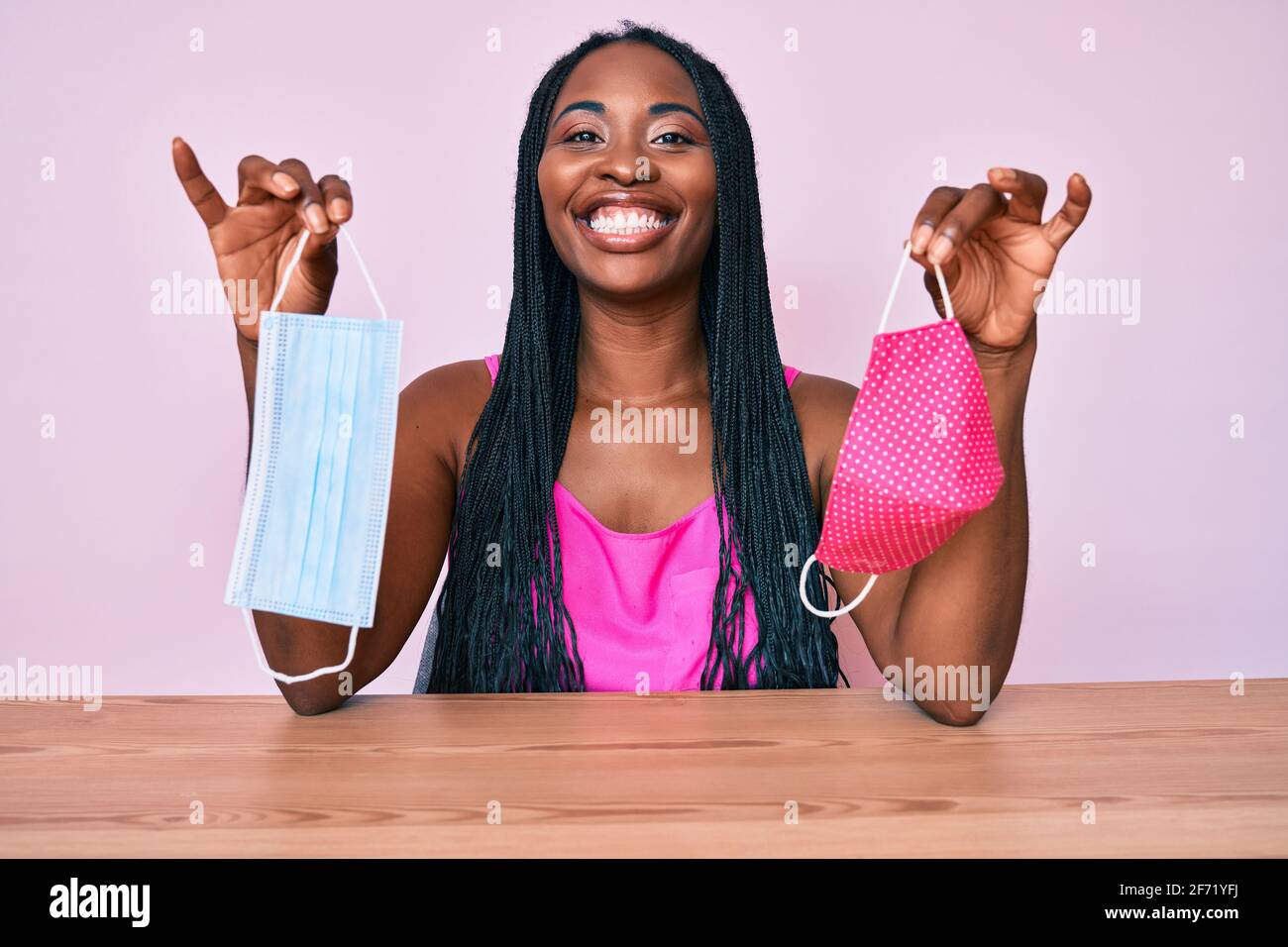 African american woman with braids holding two different safety masks ...