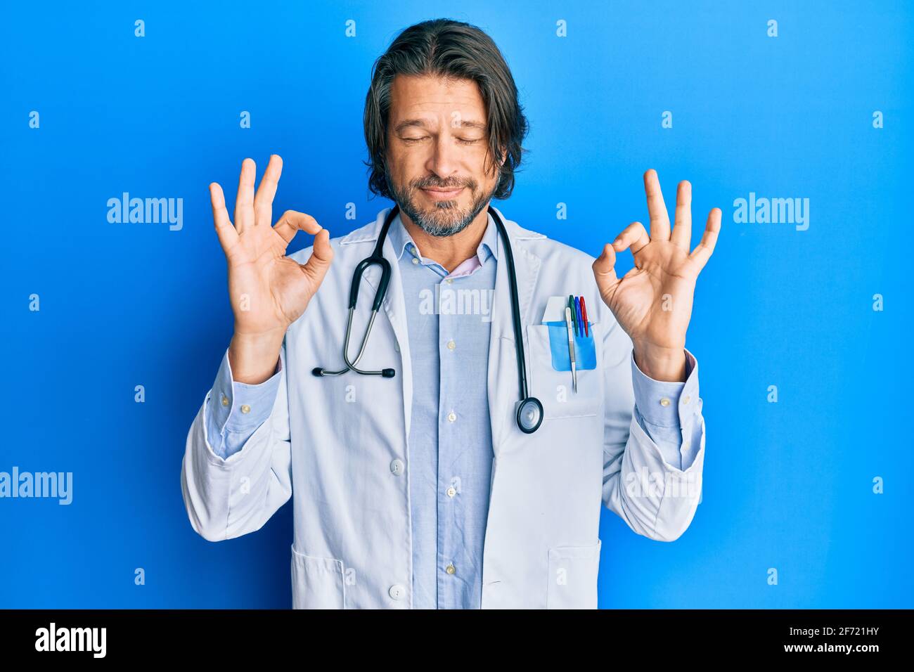Middle age handsome man wearing doctor uniform and stethoscope relax ...