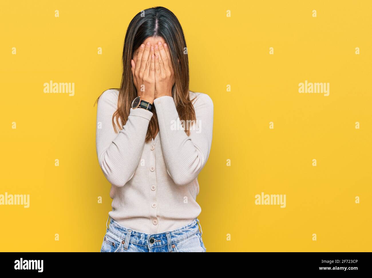 Young woman wearing casual clothes with sad expression covering face ...