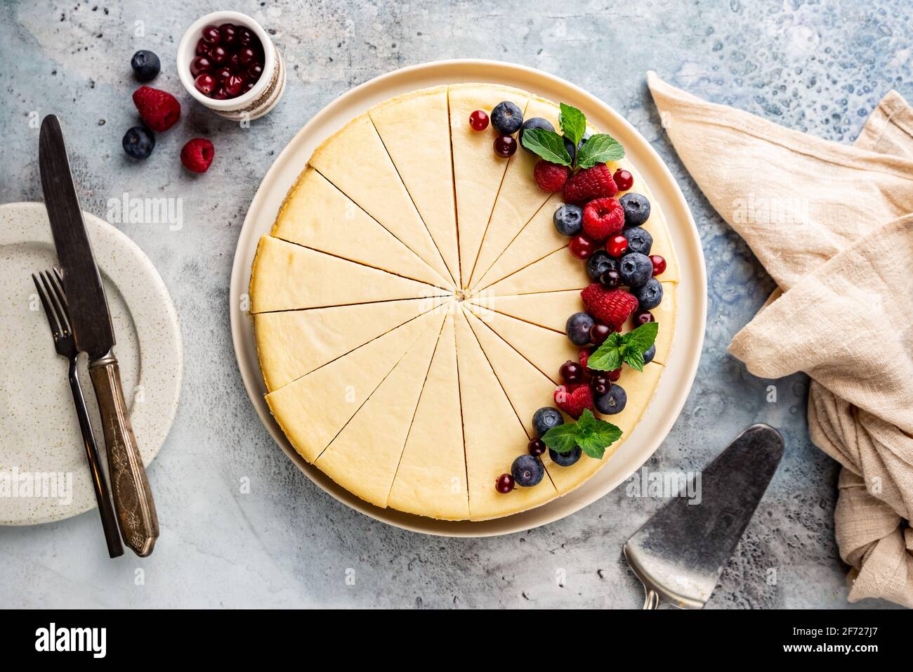 Classic New York cheesecake with fresh berries on light blue concrete ...