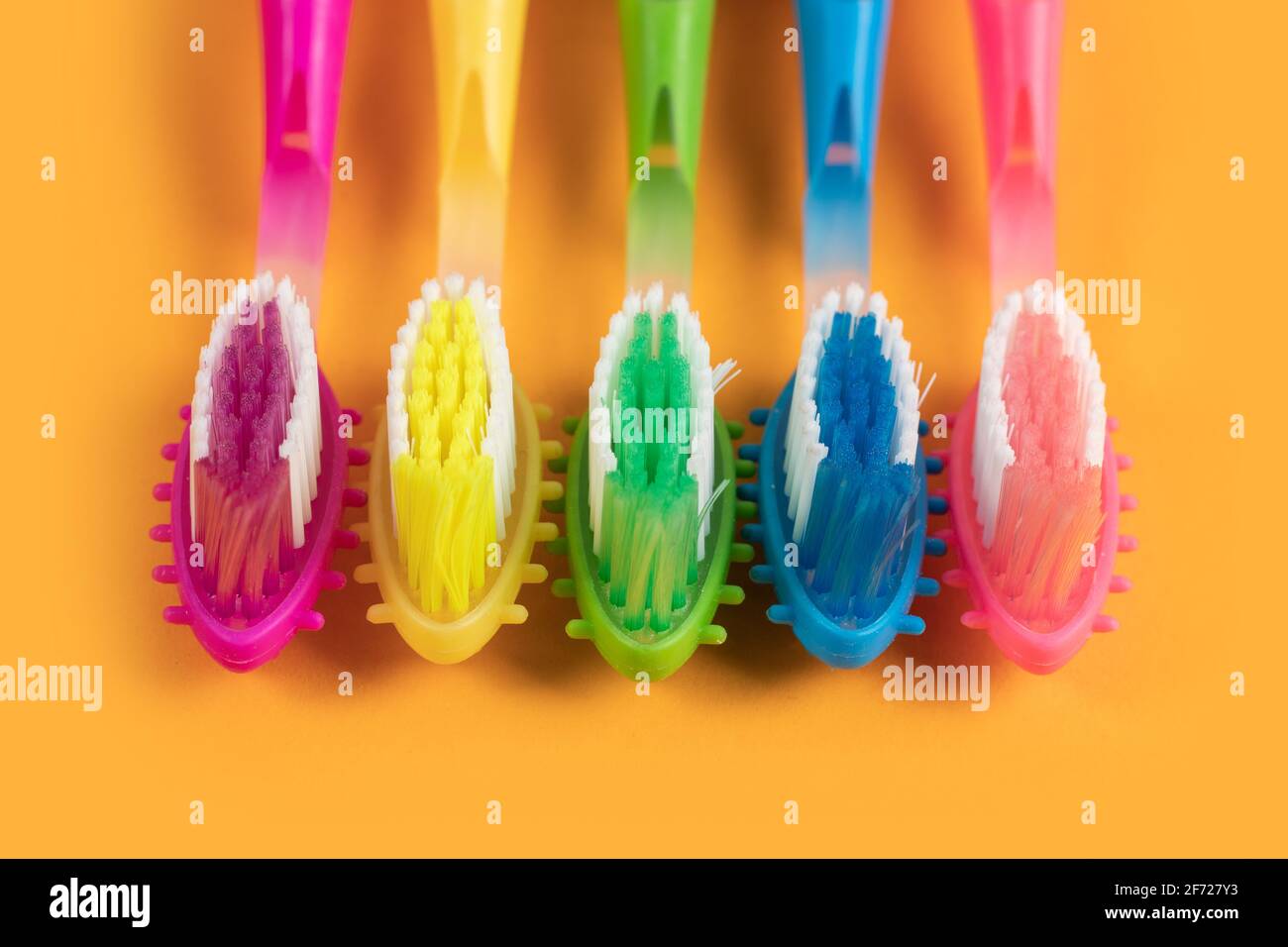 Colorful Toothbrushes on yellow background Stock Photo - Alamy