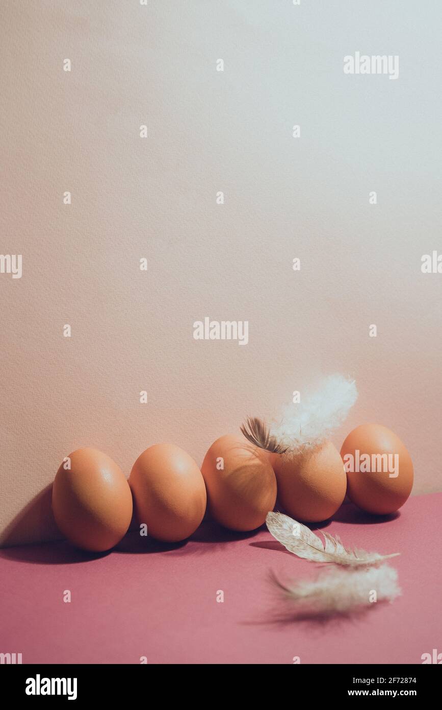 Brown eggs in cellophane on pastel pink background. modern concept of ...
