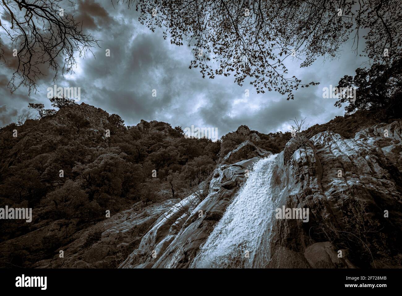 Black white cloudy sky with trees and rocky waterfall. Tropical ...