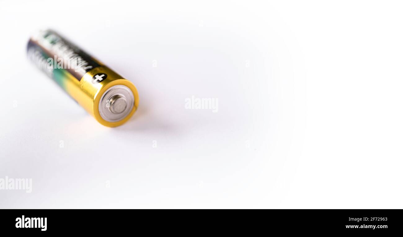 Close-up of a lying penlight battery on white, focus on the battery ...