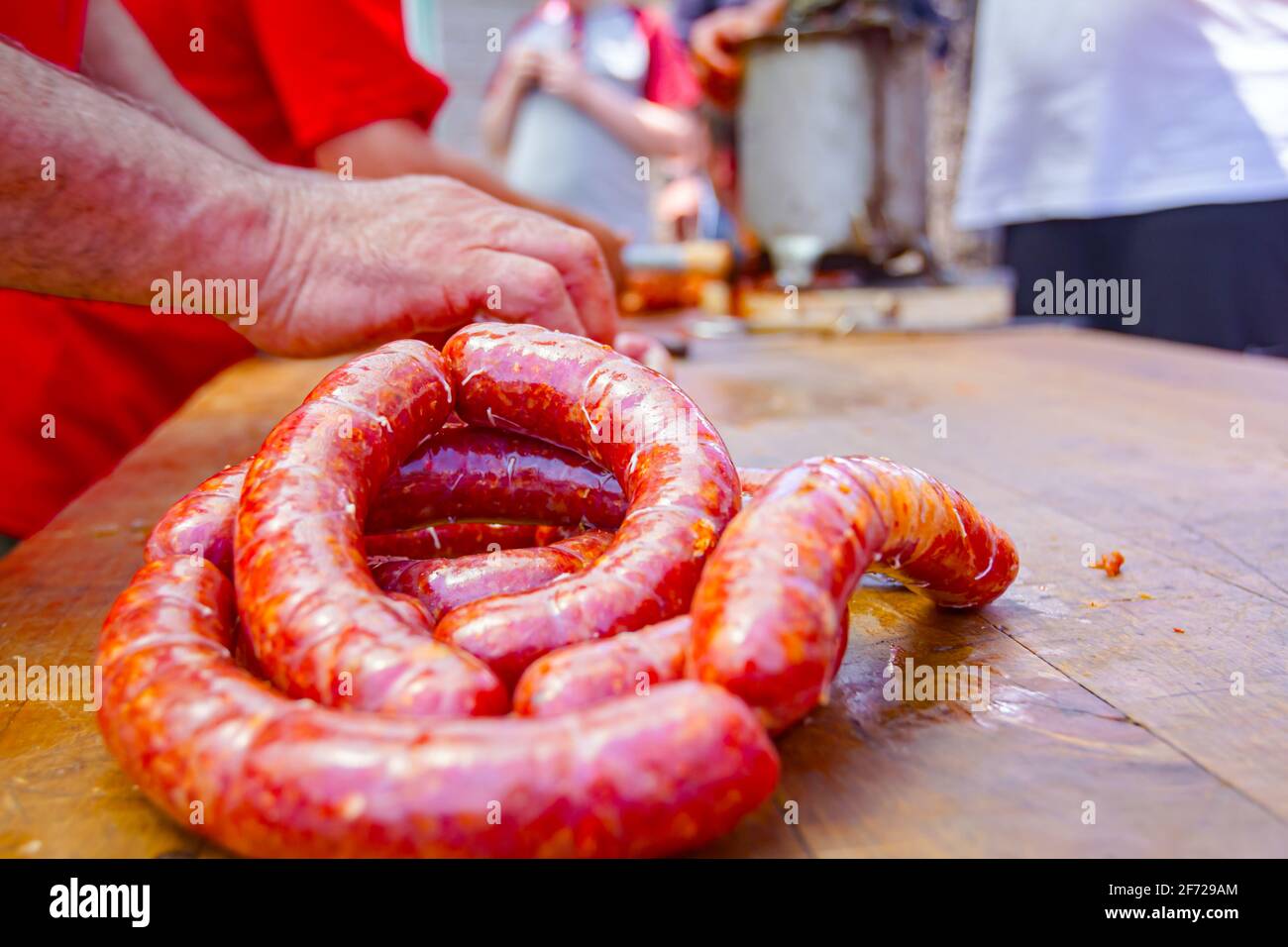 Butcher twists fresh intestine filled with minced meat, divide to make ...