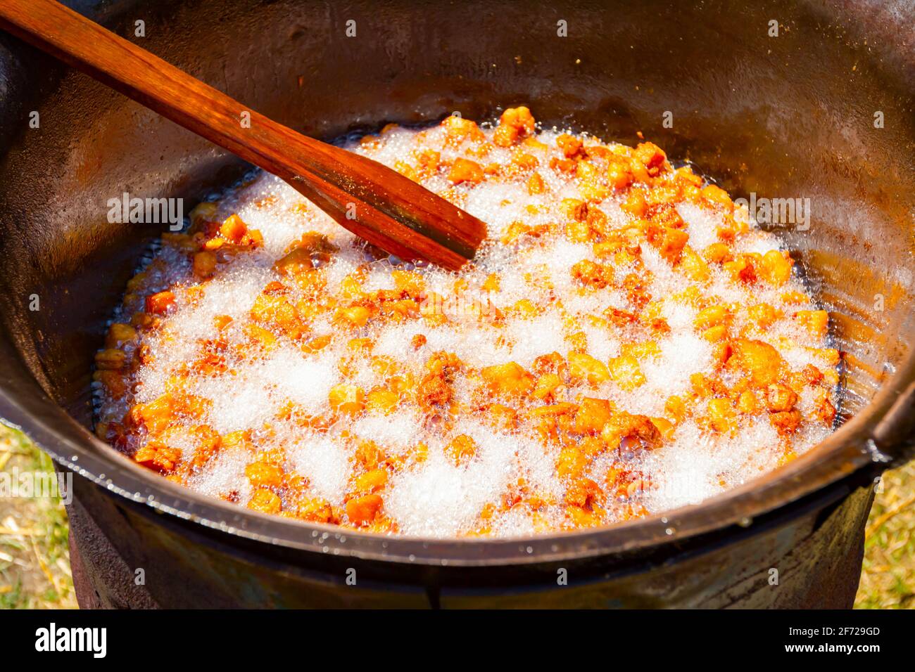 Traditional way of melting fresh pork fats, bacon, making crackling in ...