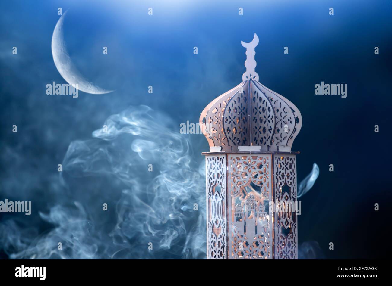 Ornamental Arabic lantern with crescent moon glowing at night. Festive ...