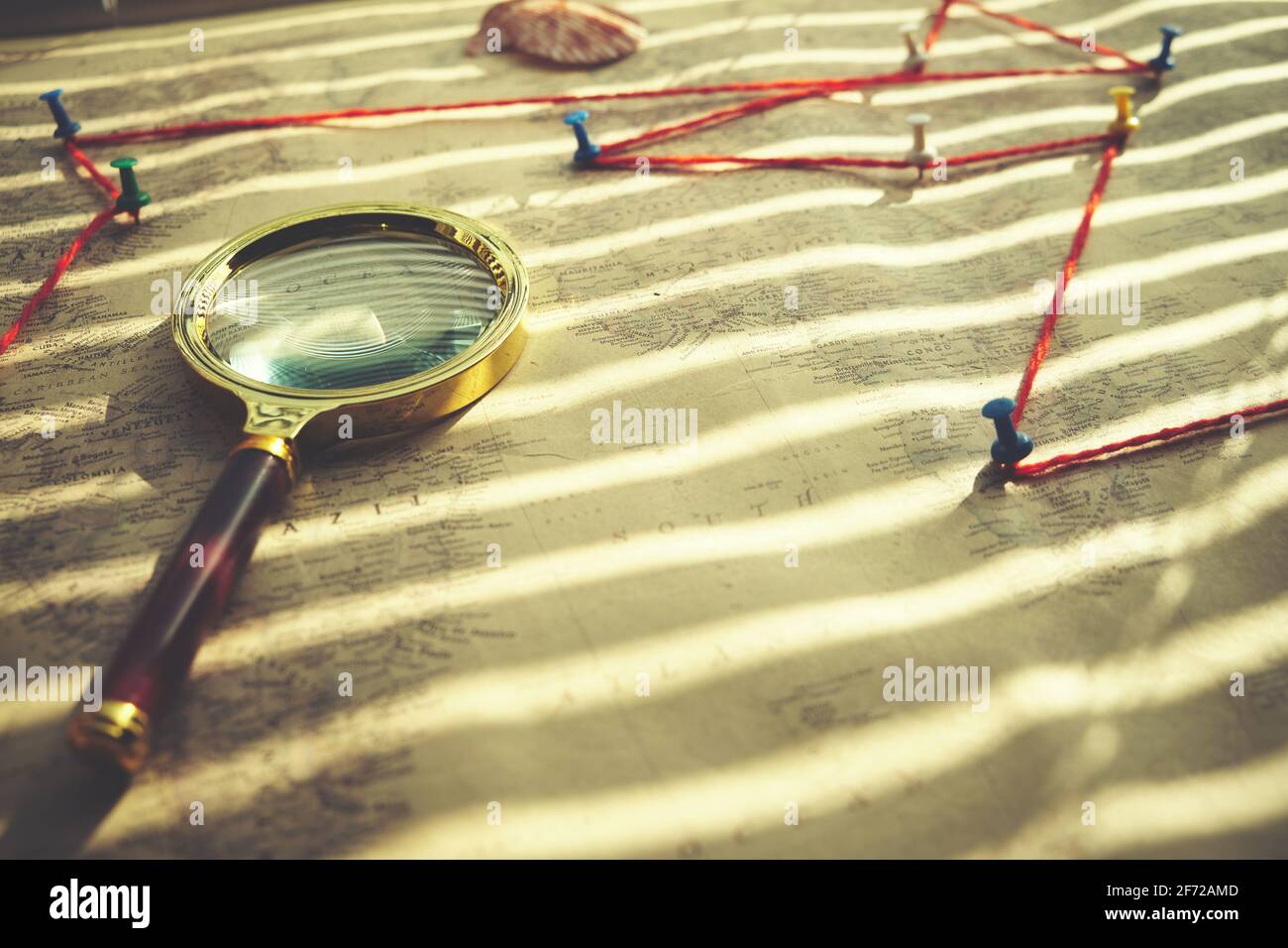 Old retro map is pressed with magnifying glass, route marked on map ...