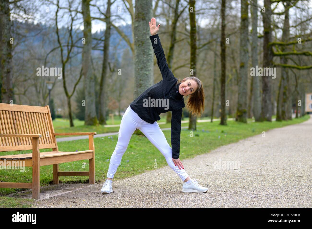 Sporty fit woman working out doing stretching exercises to tone and ...