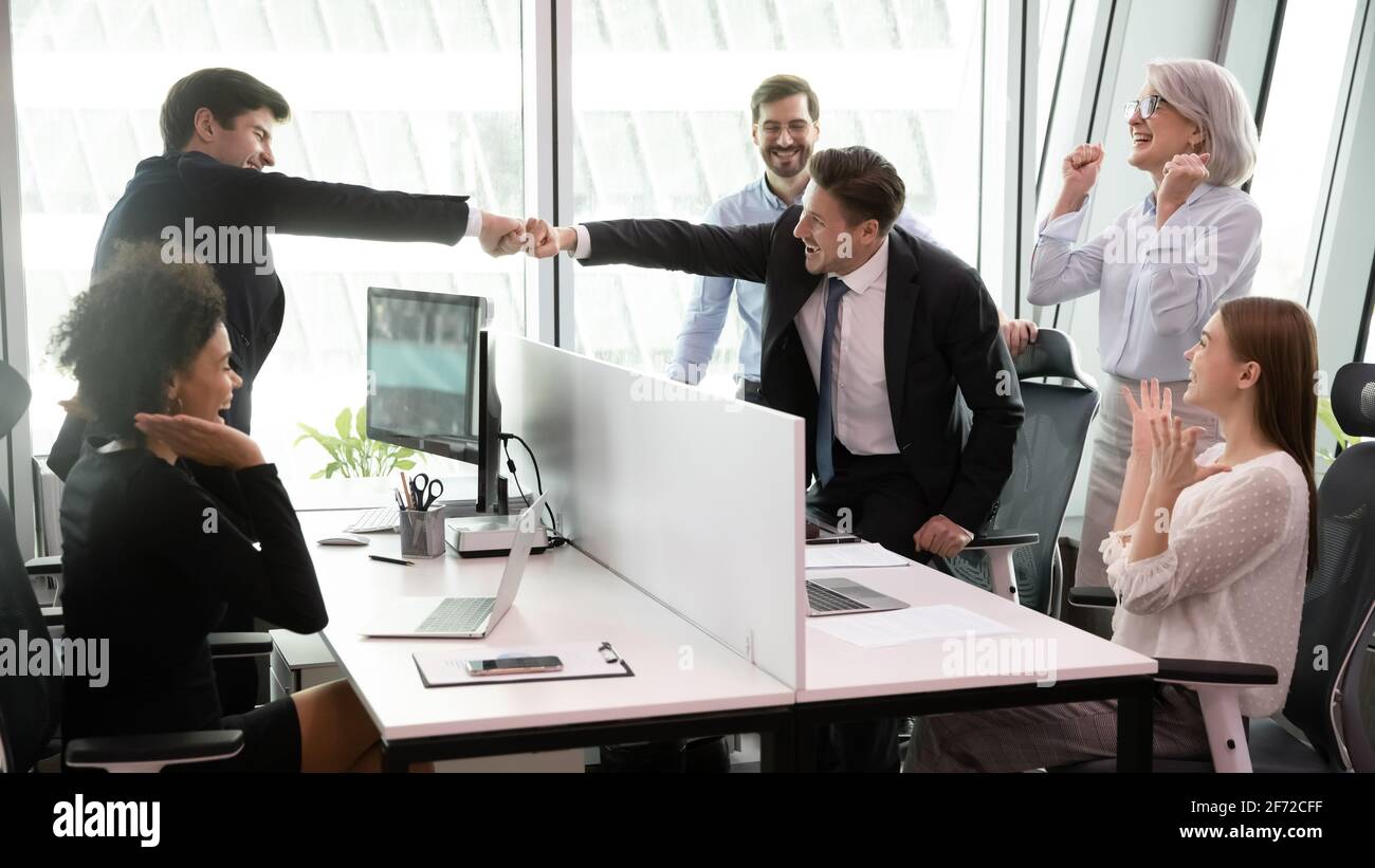 Happy male colleagues celebrate work success in office Stock Photo - Alamy