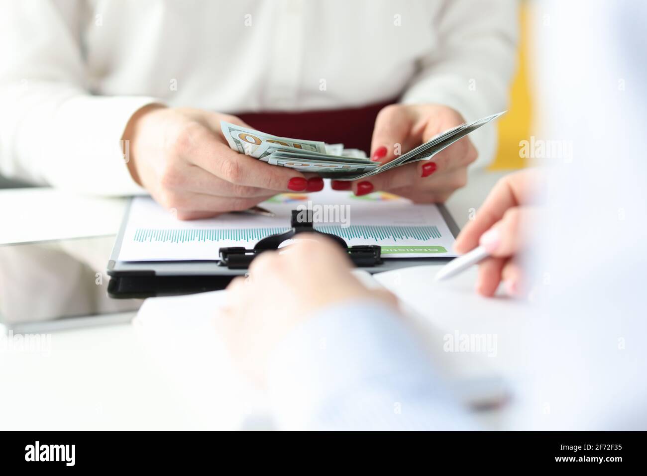Female cashier counting money。 hi-res stock photography and images - Alamy