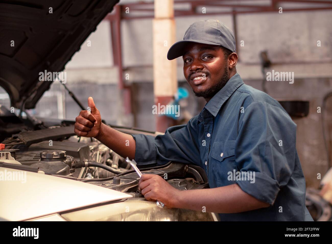 African maintenance male service checking engine system at the garage ...