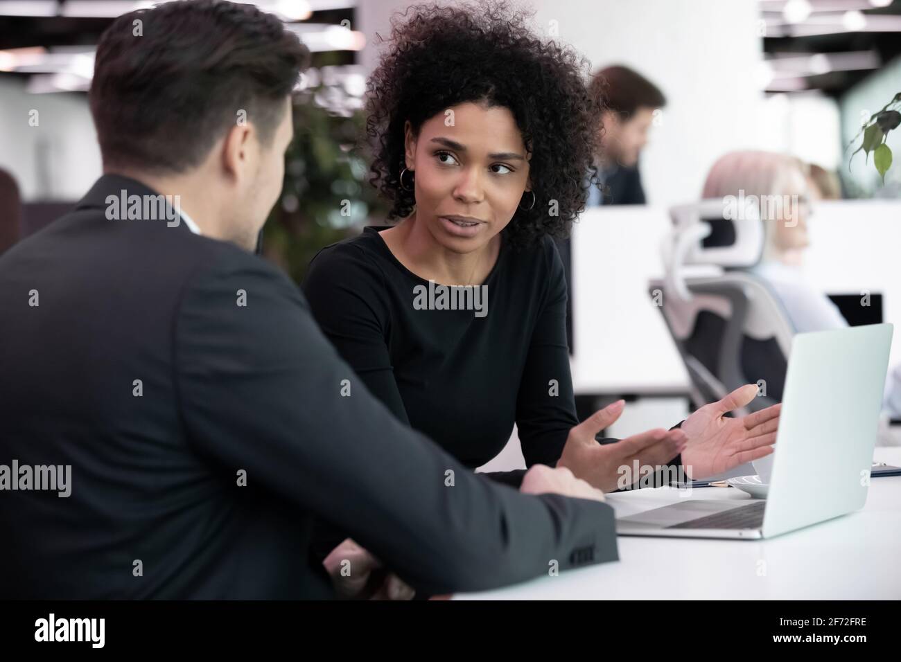 Multiethnic office colleagues using laptop hi-res stock photography and ...