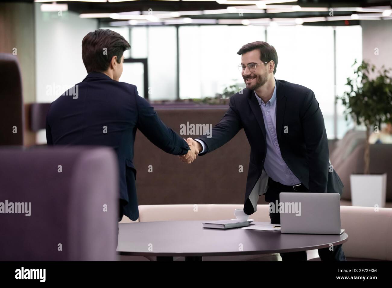 Smiling businessmen handshake closing deal at meeting Stock Photo - Alamy