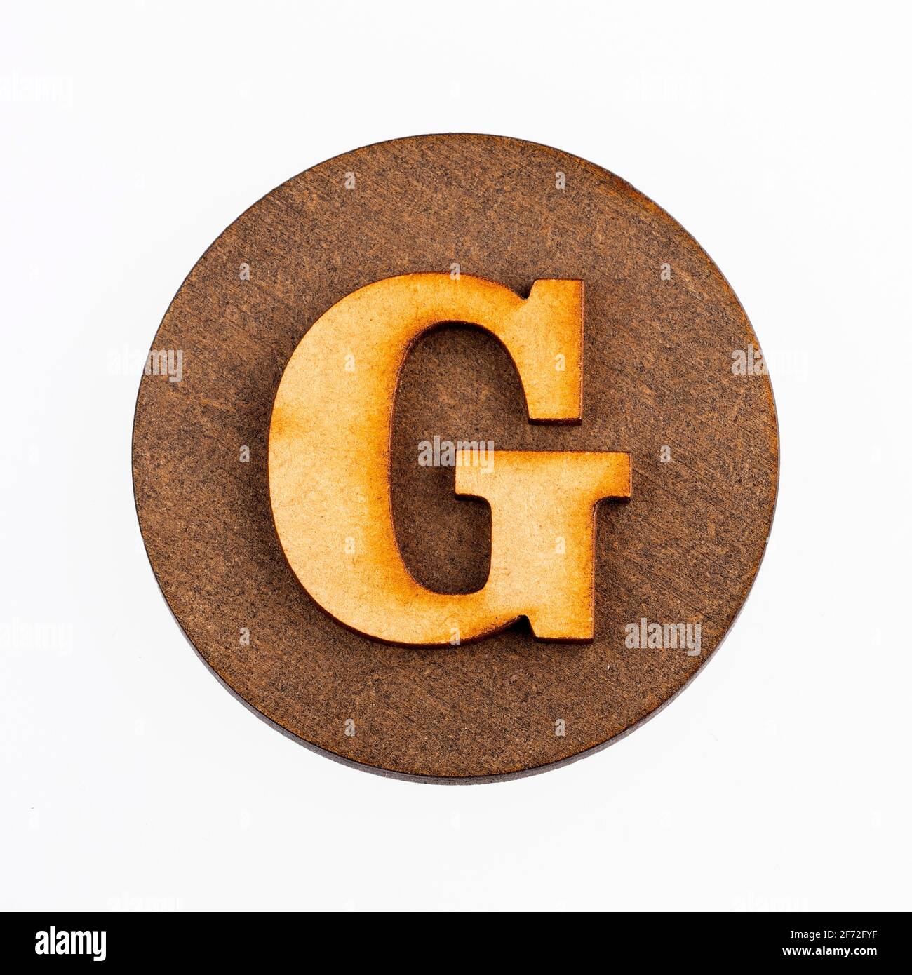 Letter G on a wood circle - Alphabet Stock Photo - Alamy