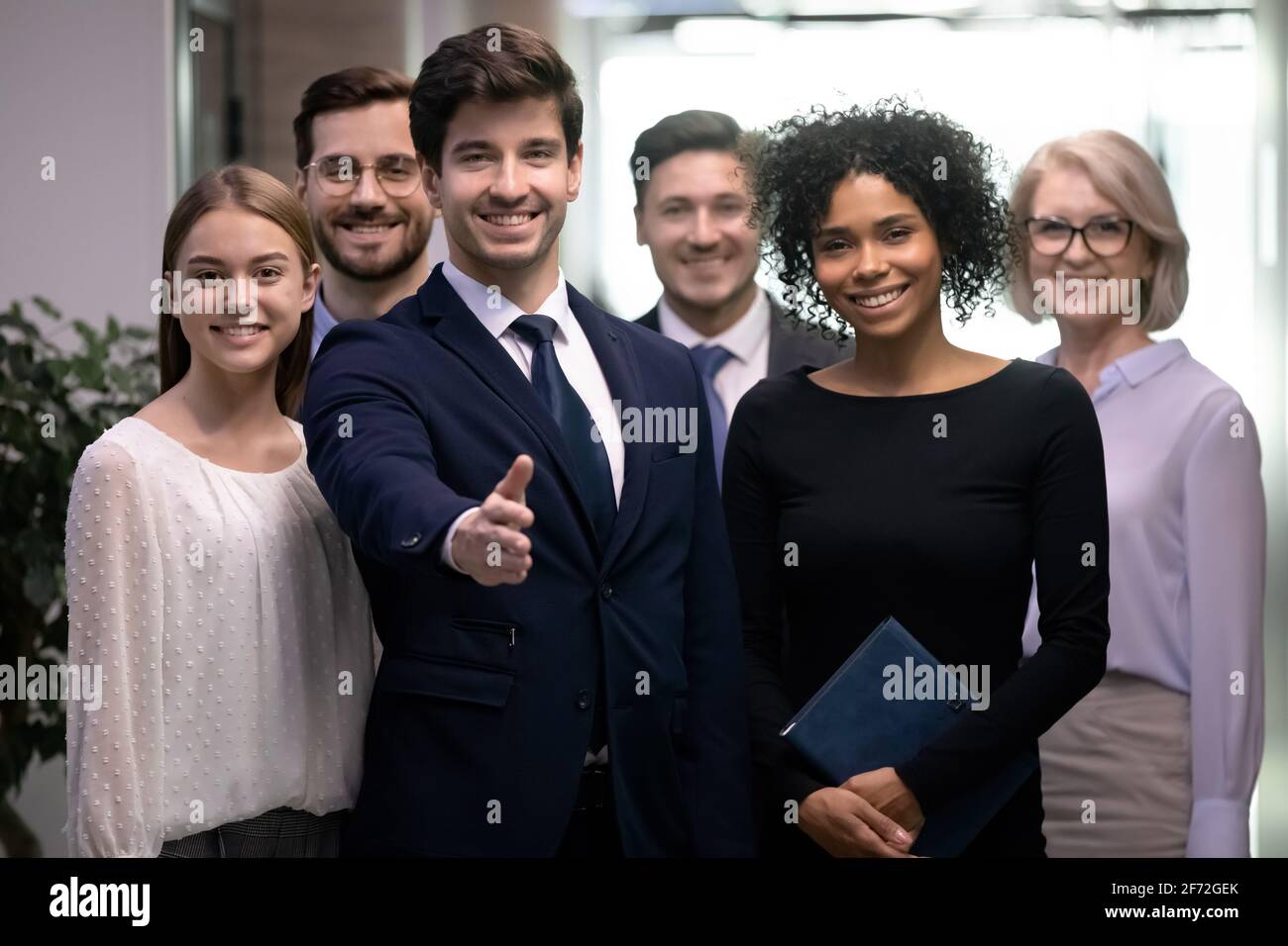 Smiling employees meet new worker into team Stock Photo - Alamy