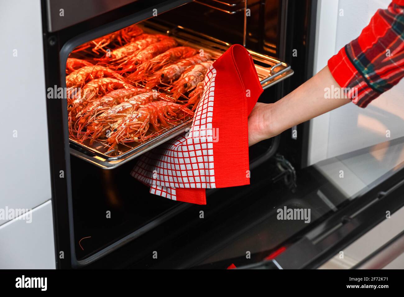 grilled shrimp and fried shrimp at home kitchen. woman holding a shrimp ...