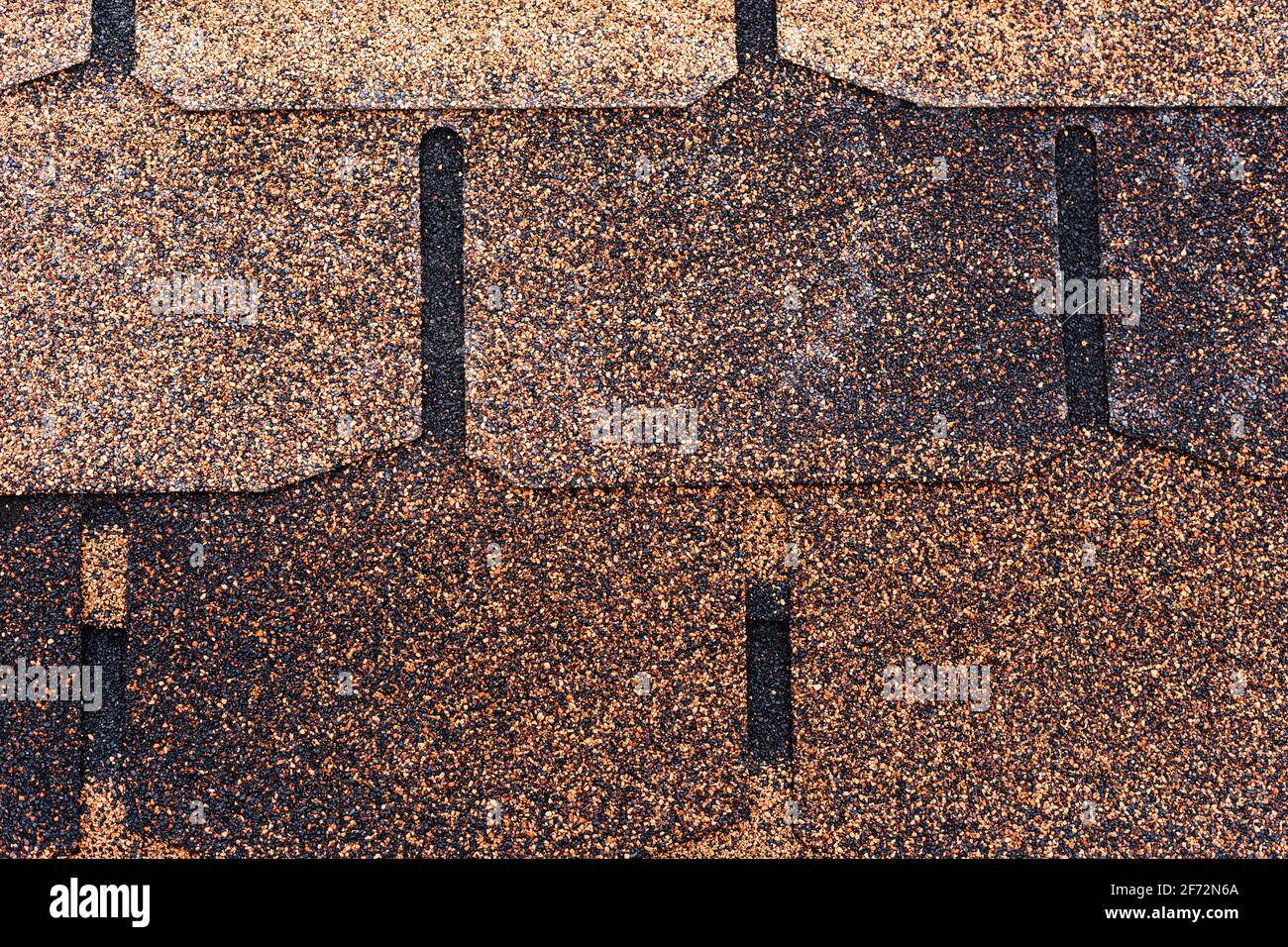 Installed brown bituminous shingles on the roof of the house close-up ...