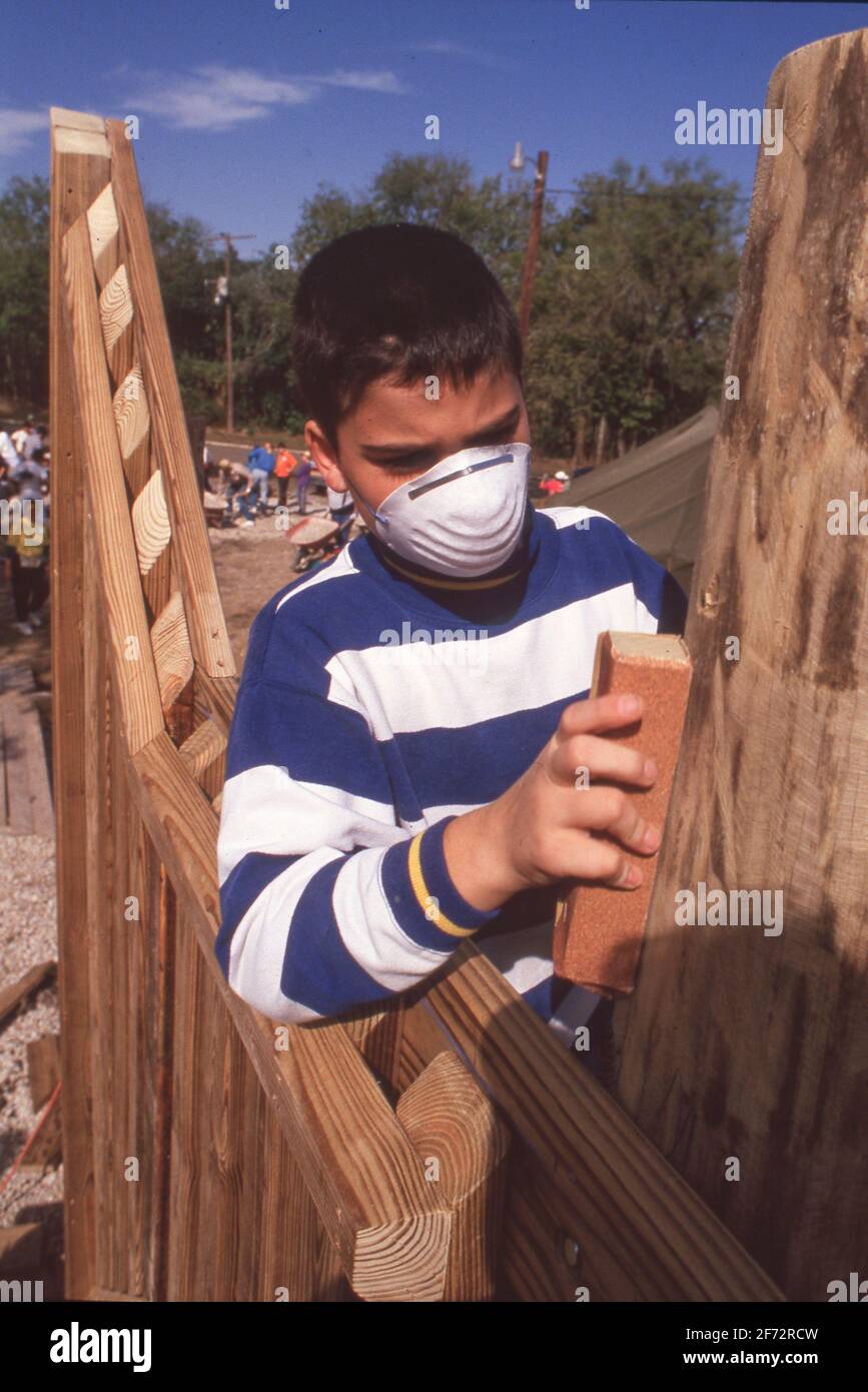 San Marcos, TX USA: Hispanic boy concentrates on sanding wood board ...