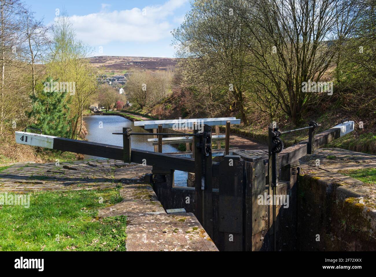 Sunny spring view of a lock on the historic Huddersfield Narrow canal ...