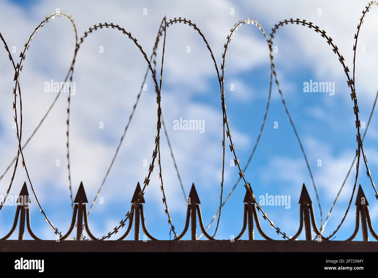 Barbed wire on fence, steel grating fence, metal fence wire. Coiled ...