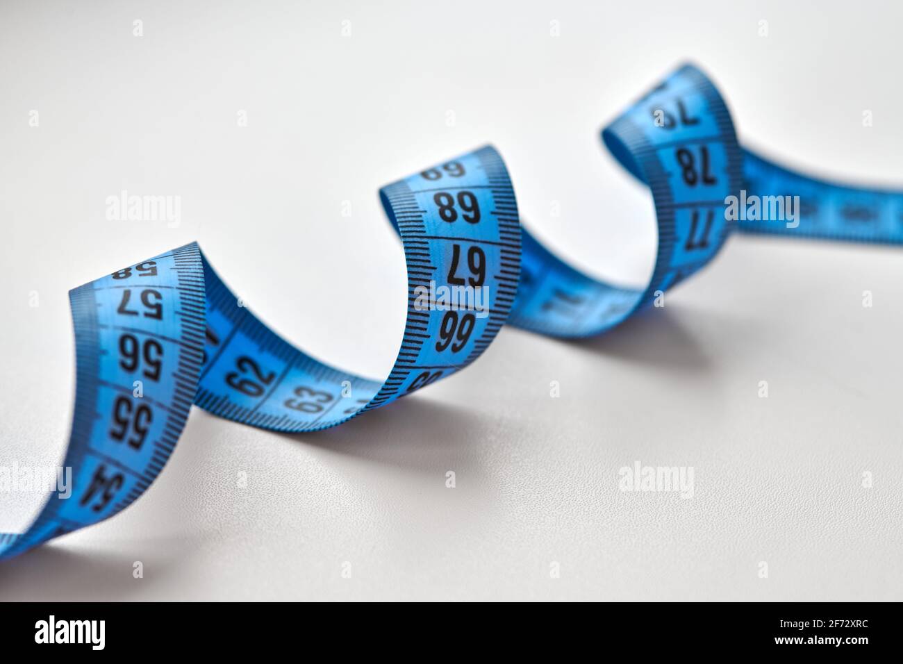 Blue measuring tape isolated on white background Stock Photo - Alamy