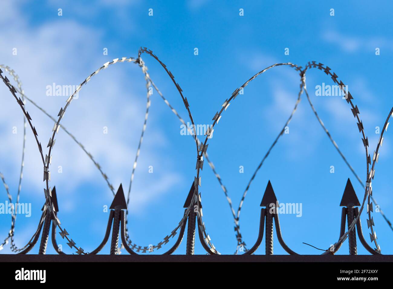 Barbed wire on fence, steel grating fence, metal fence wire. Coiled ...