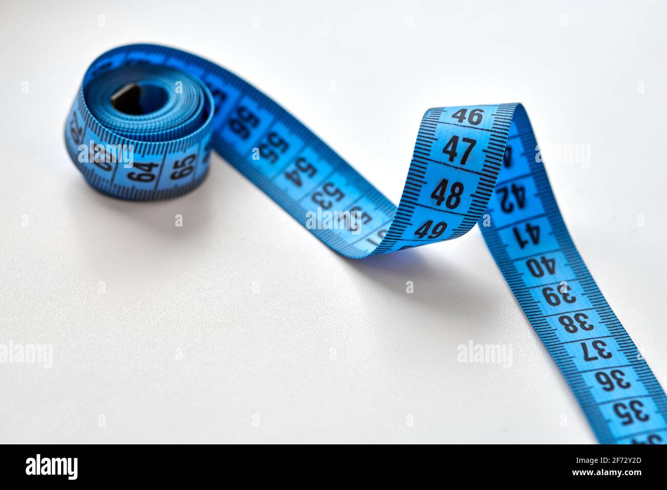Blue measuring tape isolated on white background Stock Photo - Alamy