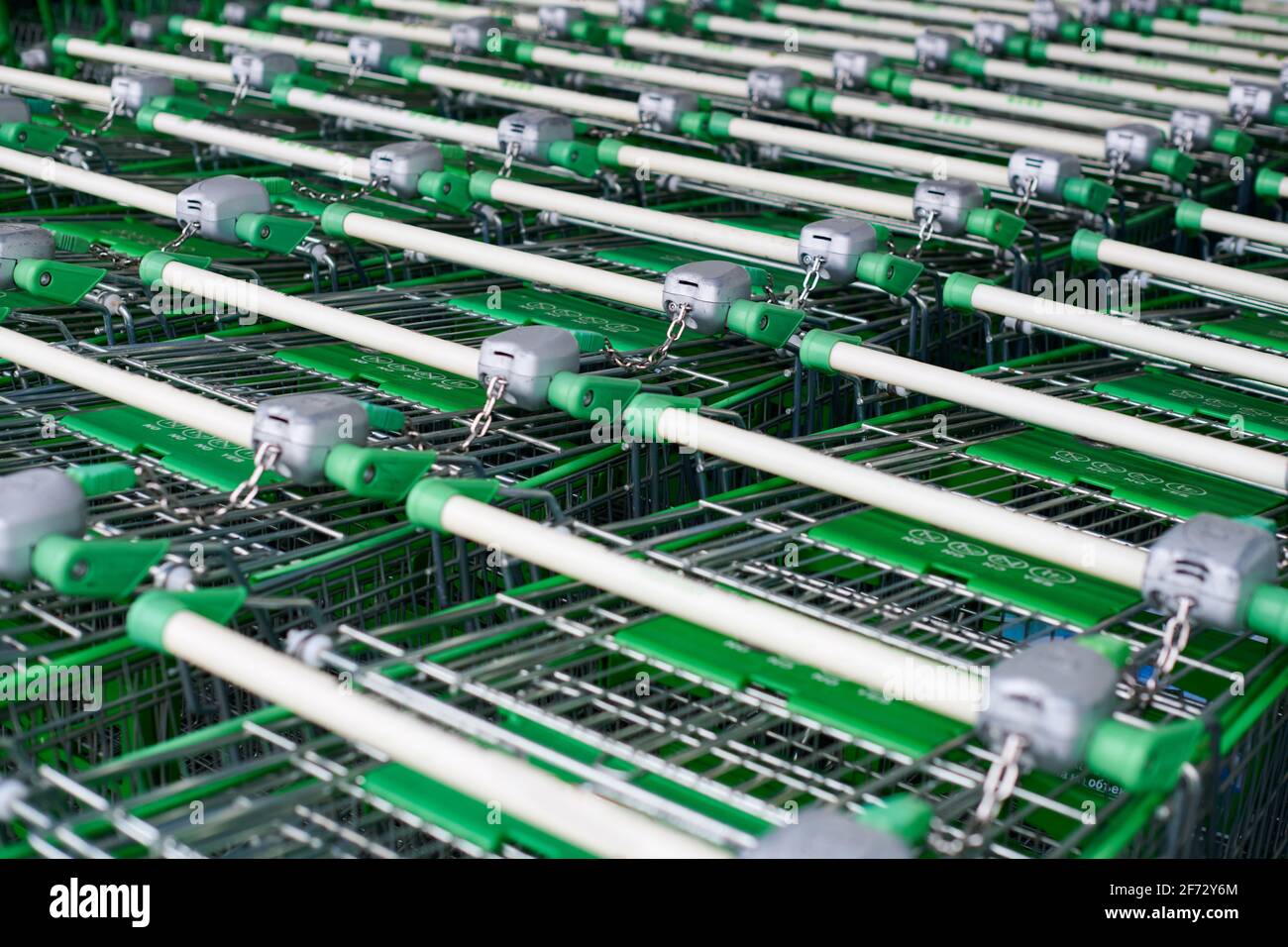 Many empty green shopping carts in row. Row of parked trolleys in ...