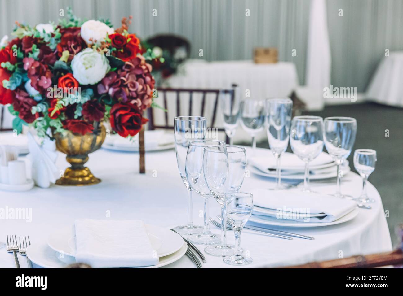 Fancy table set for dinner with flower composition in restaurant ...