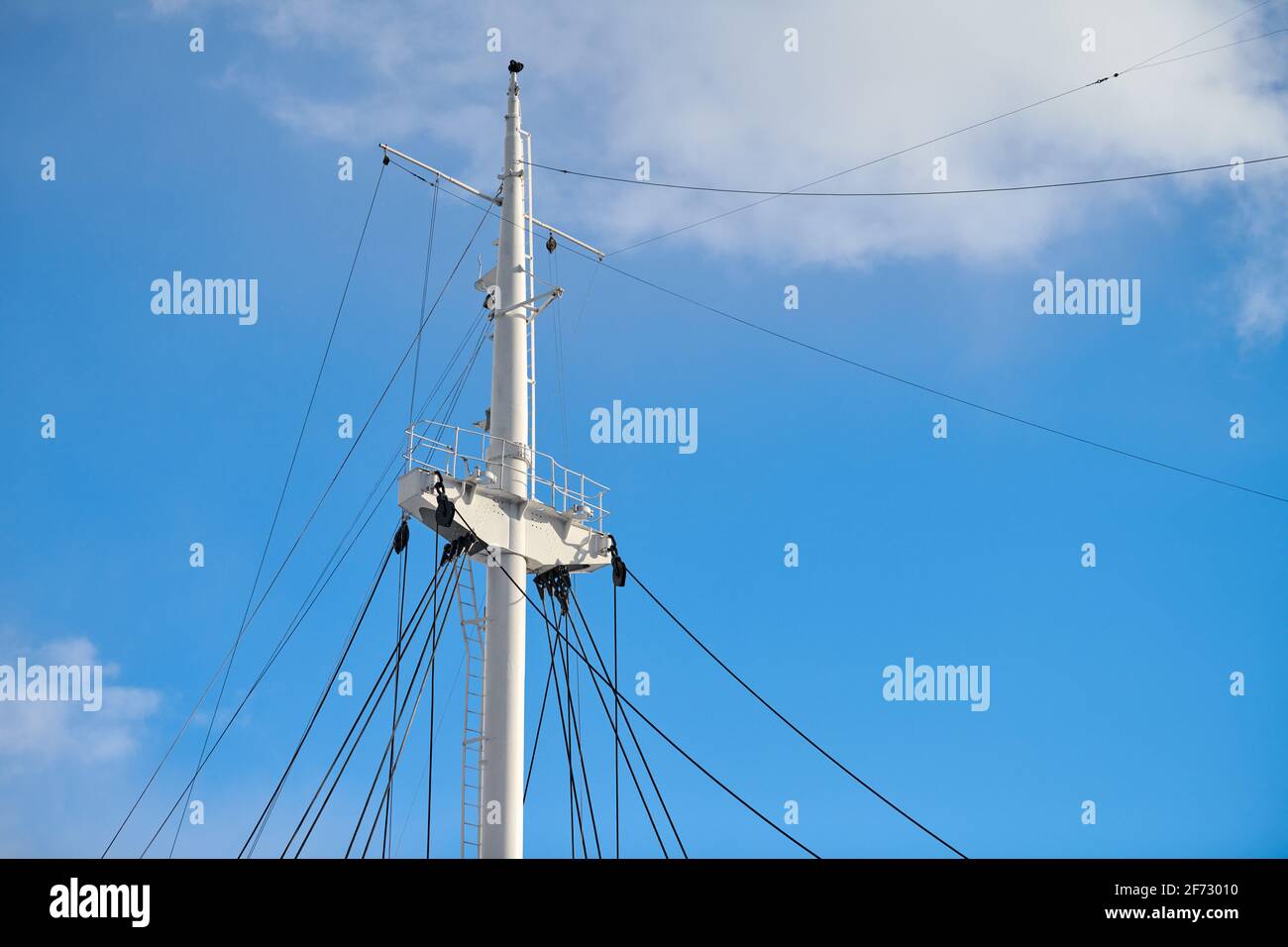 Sailing mast of ship on blue cloudy sky background, copy space. Sailing ...