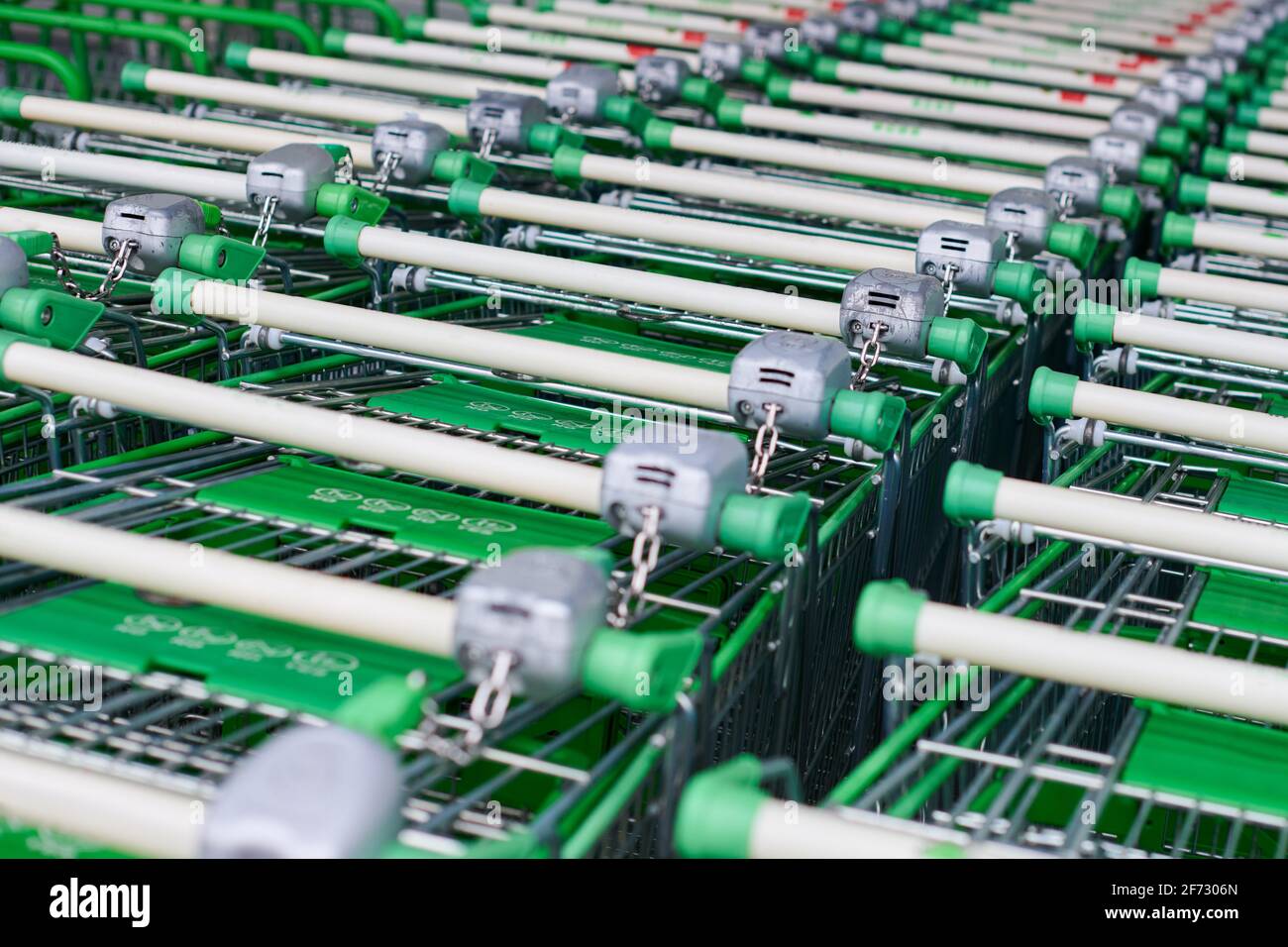 Many empty green shopping carts in row. Row of parked trolleys in ...