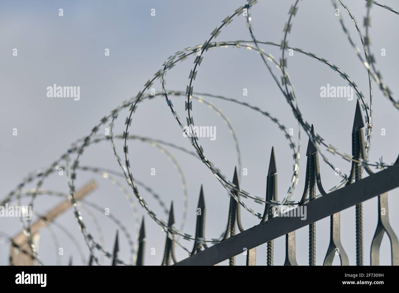 Barbed wire on fence, steel grating fence, metal fence wire. Coiled ...