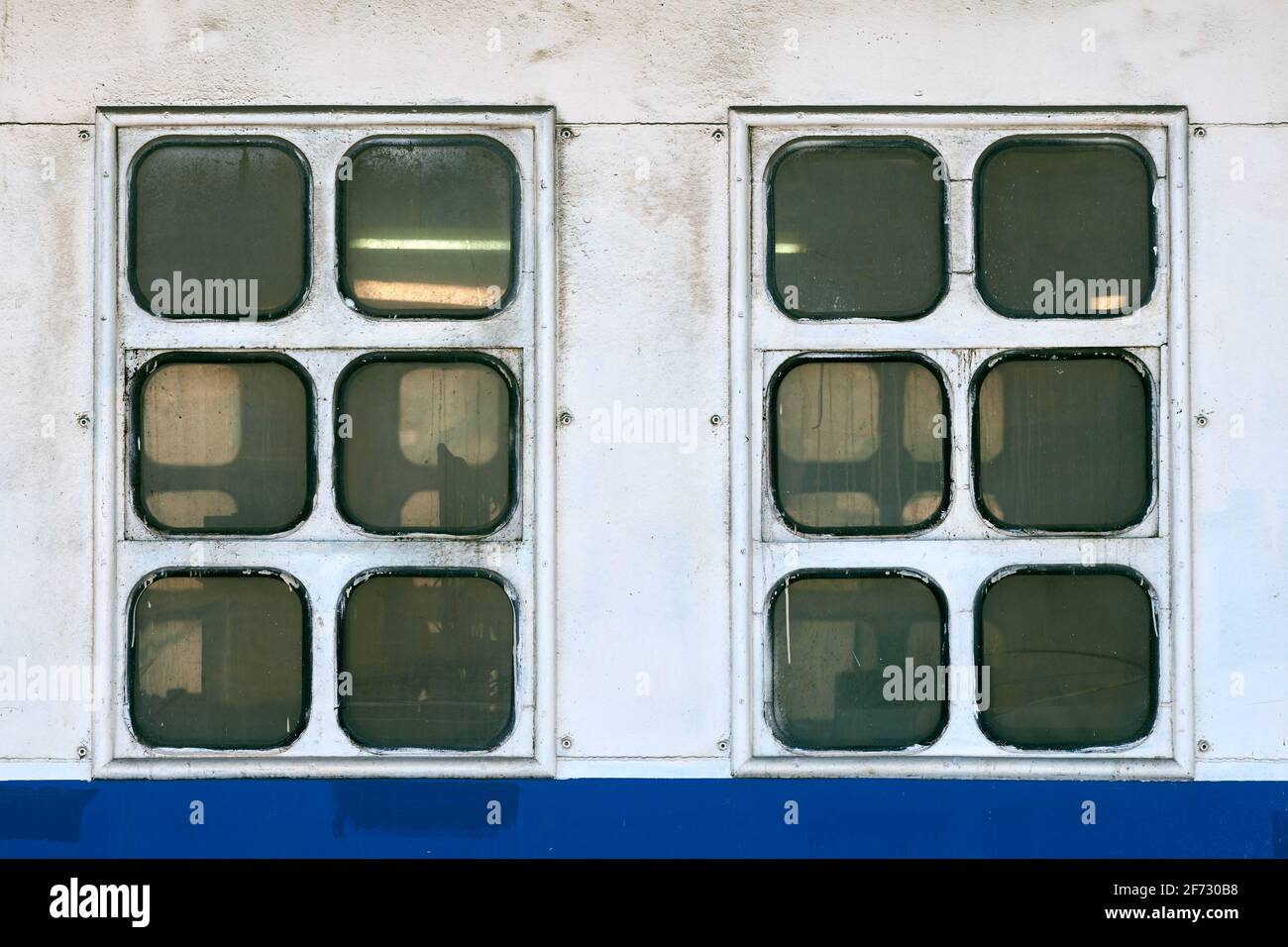 Two cabin windows and portholes on outboard side of ship. Close up of ...