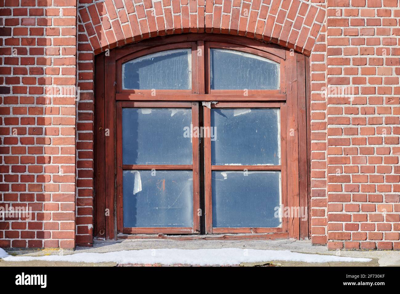 One arched glass window on old red brick wall. Vintage window in brown ...