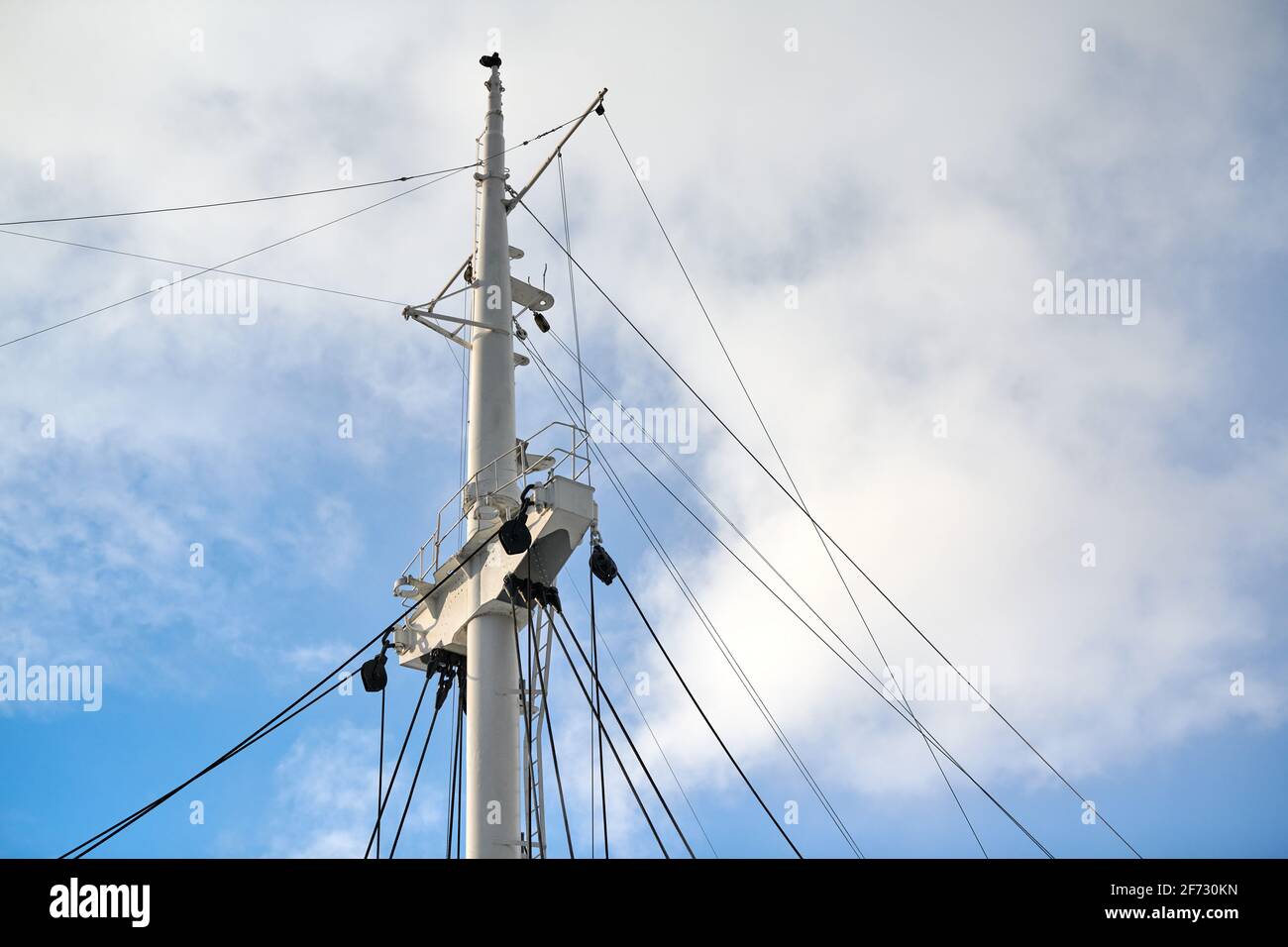 Sailing mast of ship on blue cloudy sky background, copy space. Sailing ...